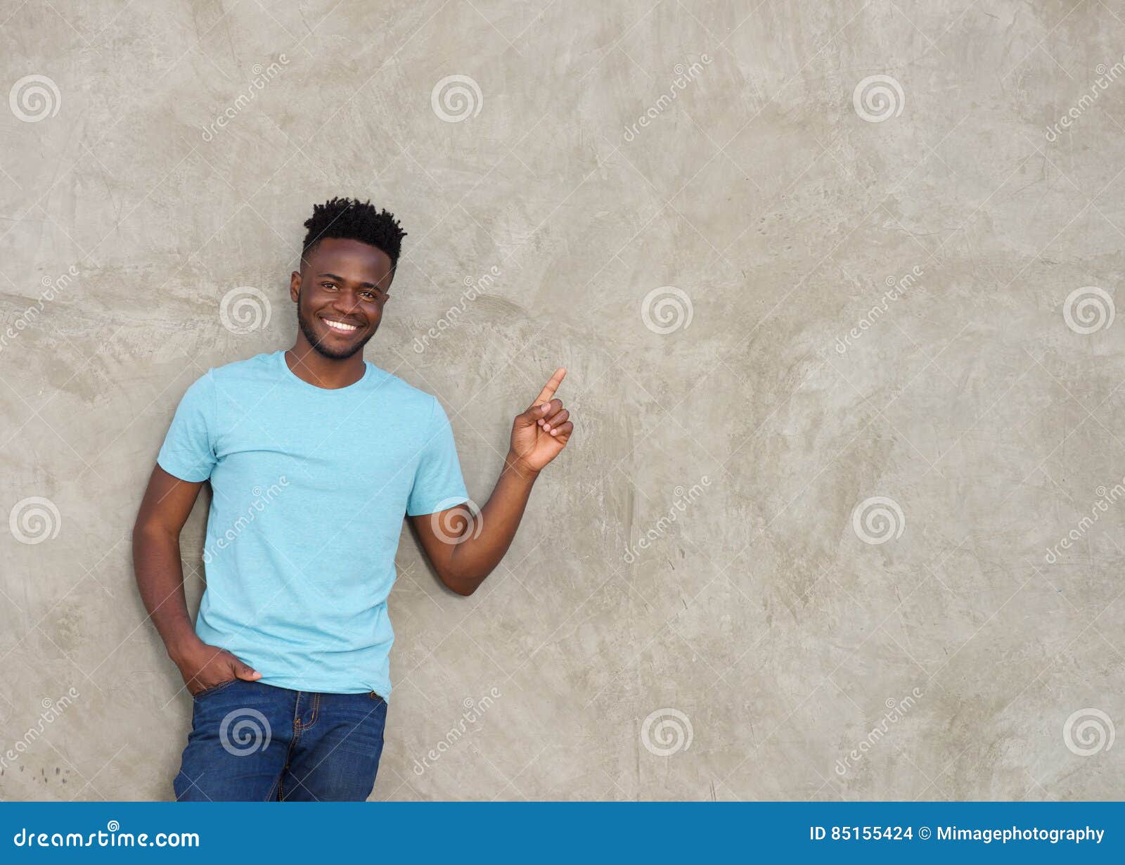Confident Young Man Pointing and Smiling Stock Photo - Image of ...
