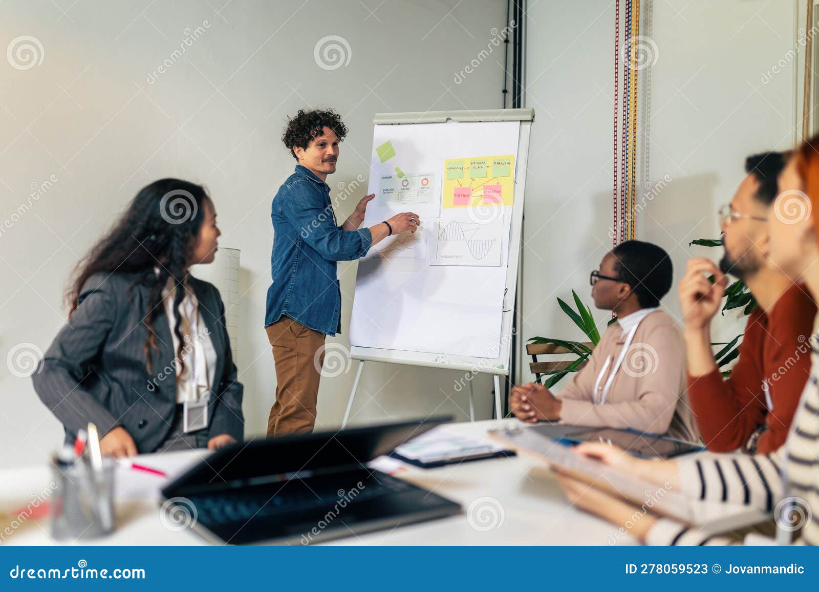Young Team Leader Giving a Presentation To a Group of Young Colleagues ...
