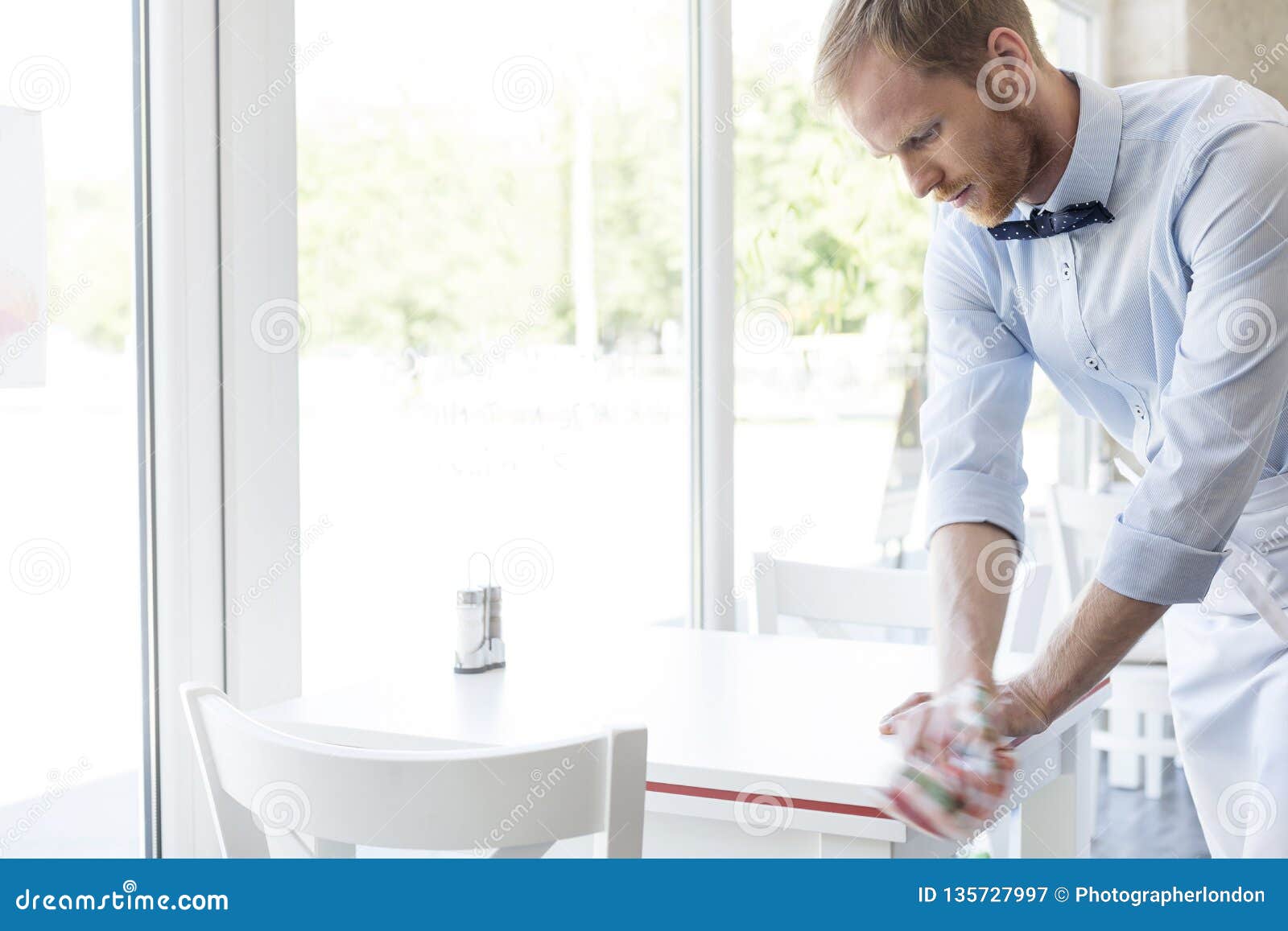 Confident Young Waiter Cleaning Table at Restaurant Stock Image - Image ...