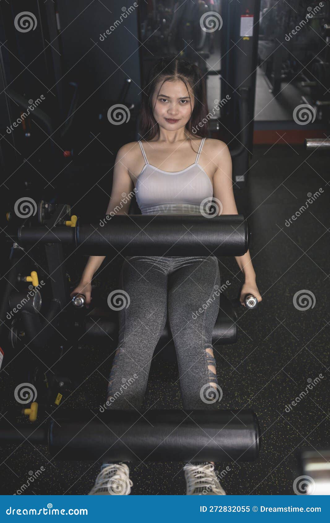 A Confident Young Woman Does Leg Extensions. Using a Leg Extension ...
