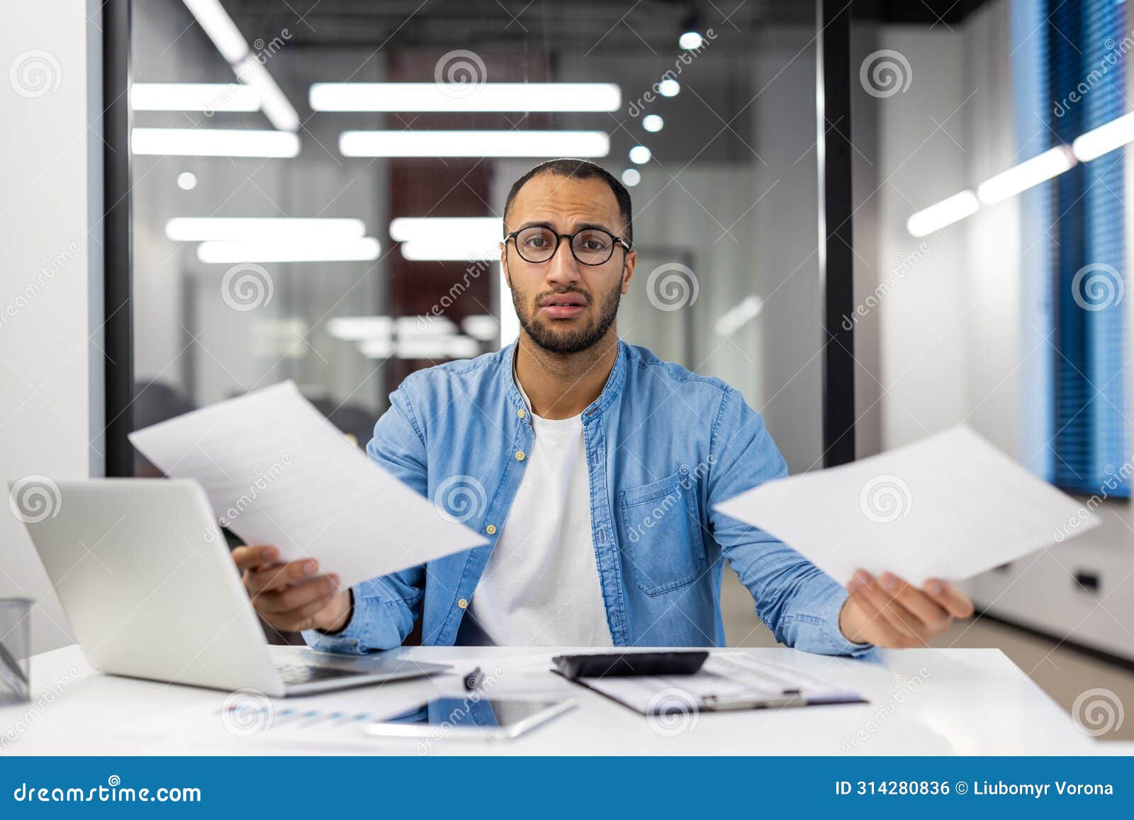Confused Businessman Analyzing Paperwork in Modern Office Stock Photo ...