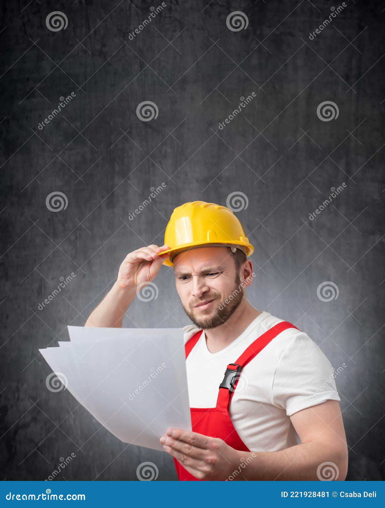 A Confused Construction Worker Holding Papers or Documents Stock Image ...