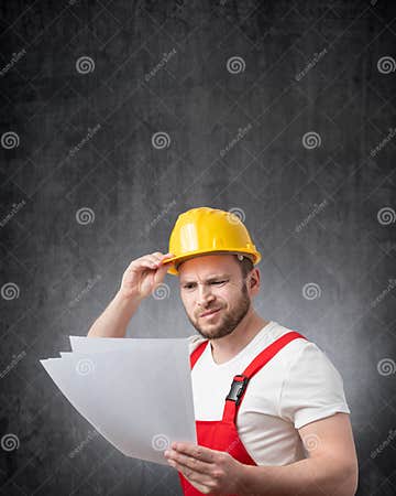 A Confused Construction Worker Holding Papers or Documents Stock Image ...