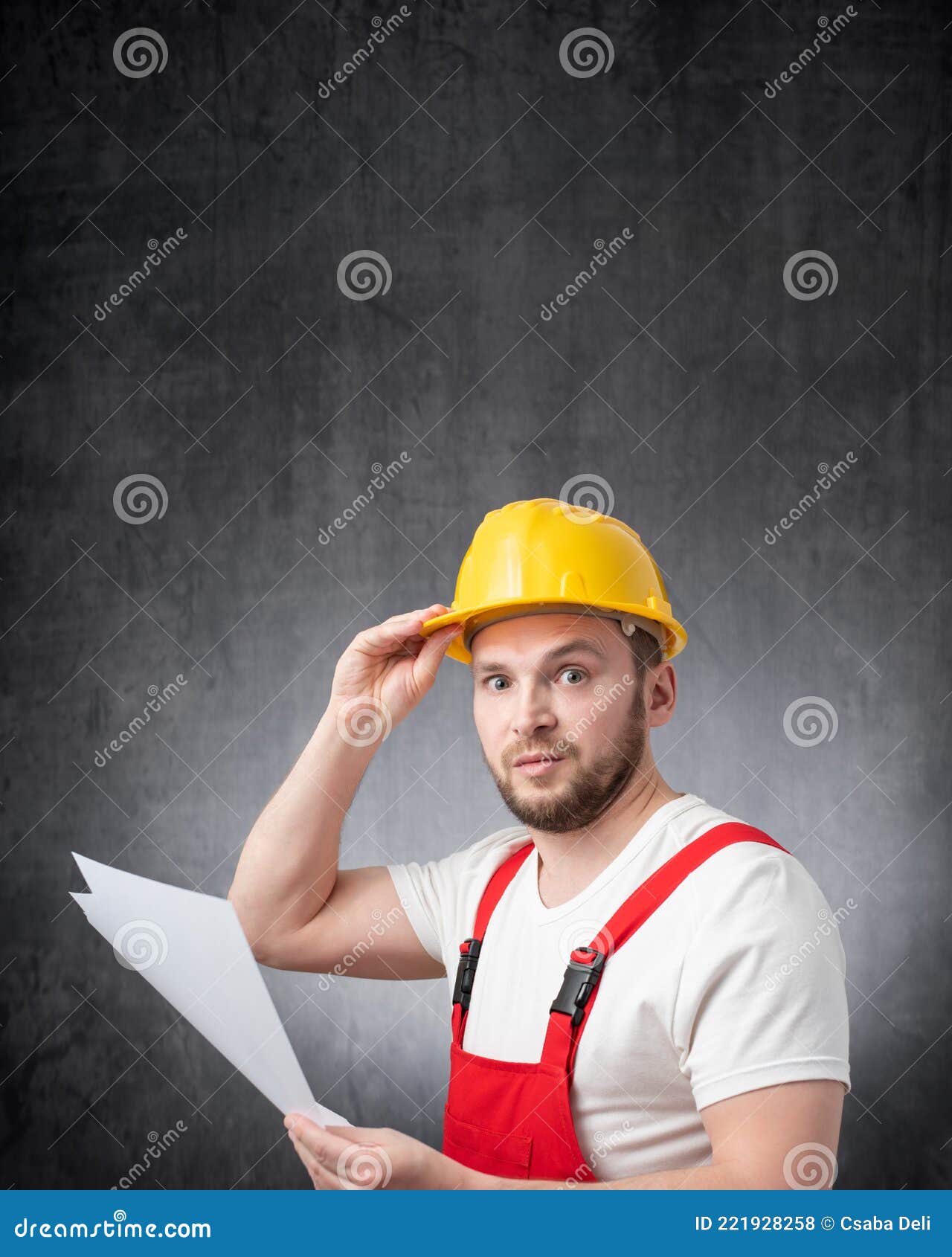 A Confused Construction Worker Holding Papers or Documents Stock Photo ...