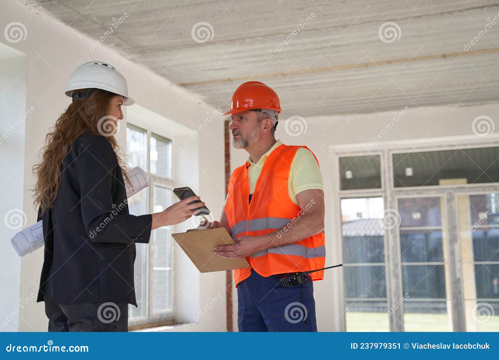 Confused Construction Worker Looking at Engineer while Writing from ...