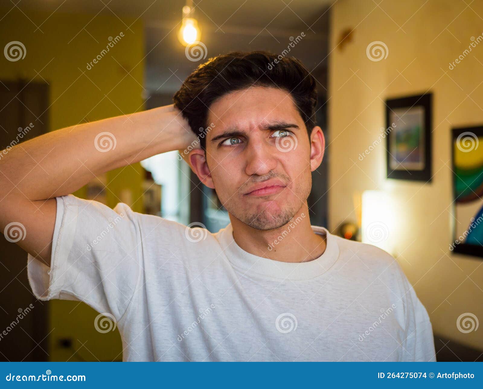 Confused Or Doubtful Young Man Scratching His Head And Looking Up Stock