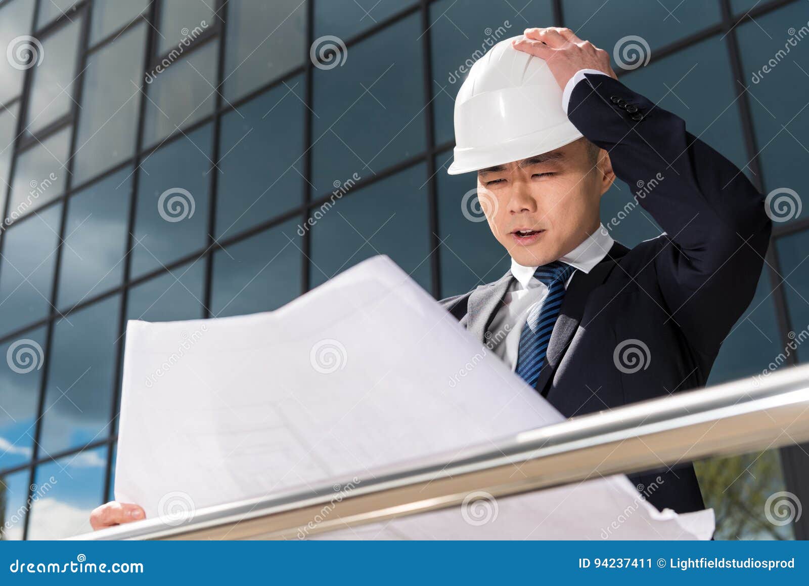 Confused Professional Architect in Hard Hat Looking at Blueprint Stock ...