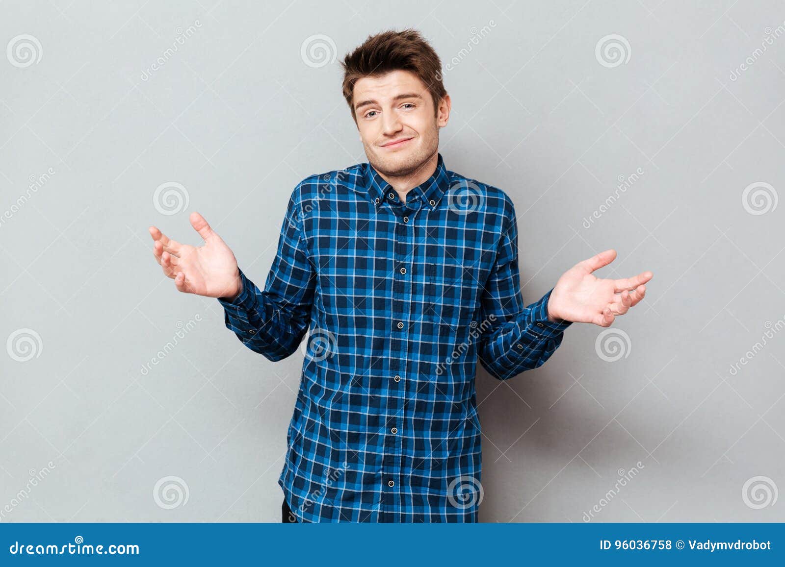 Confused Young Man Standing Over Grey Wall Stock Photo - Image of ...