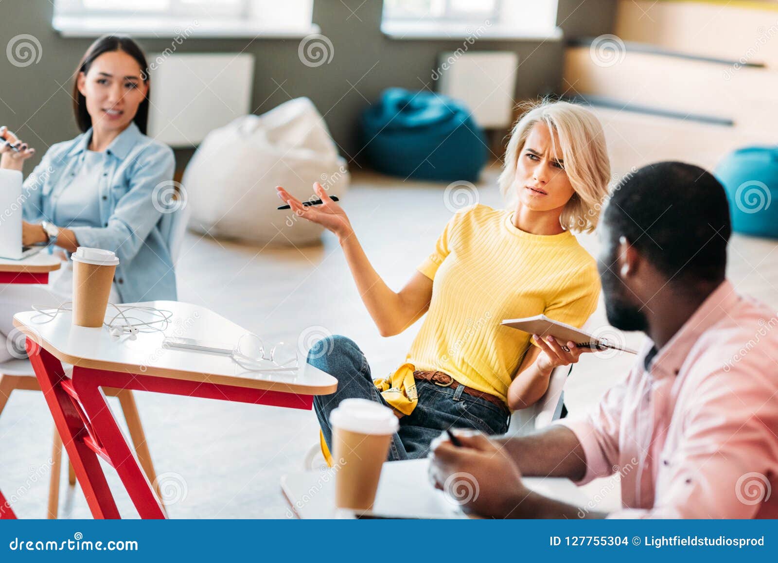 Confused Young Students Sitting Together Stock Photo - Image of ...
