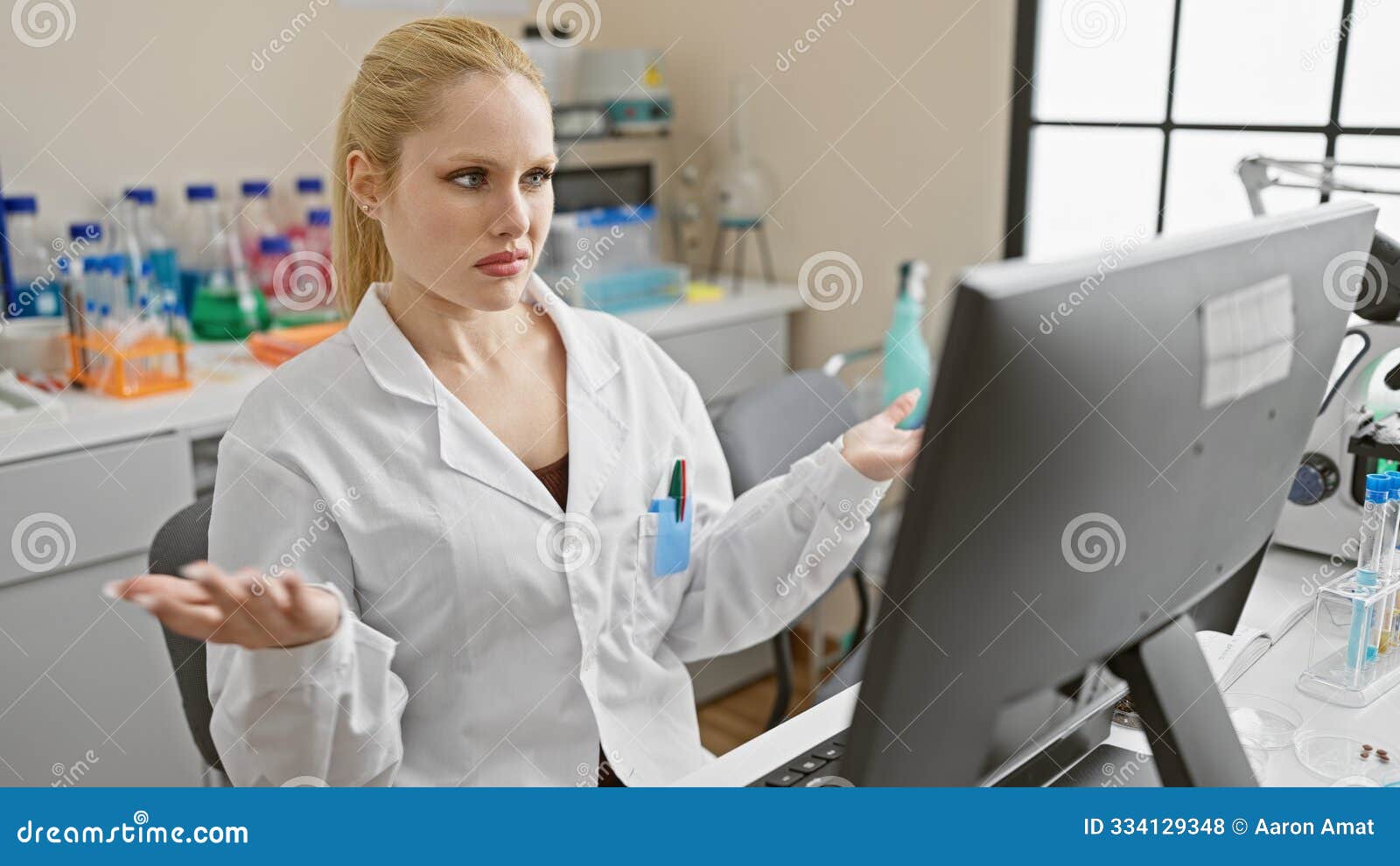 Confused Young Woman Scientist Examining Data on Computer in Laboratory ...