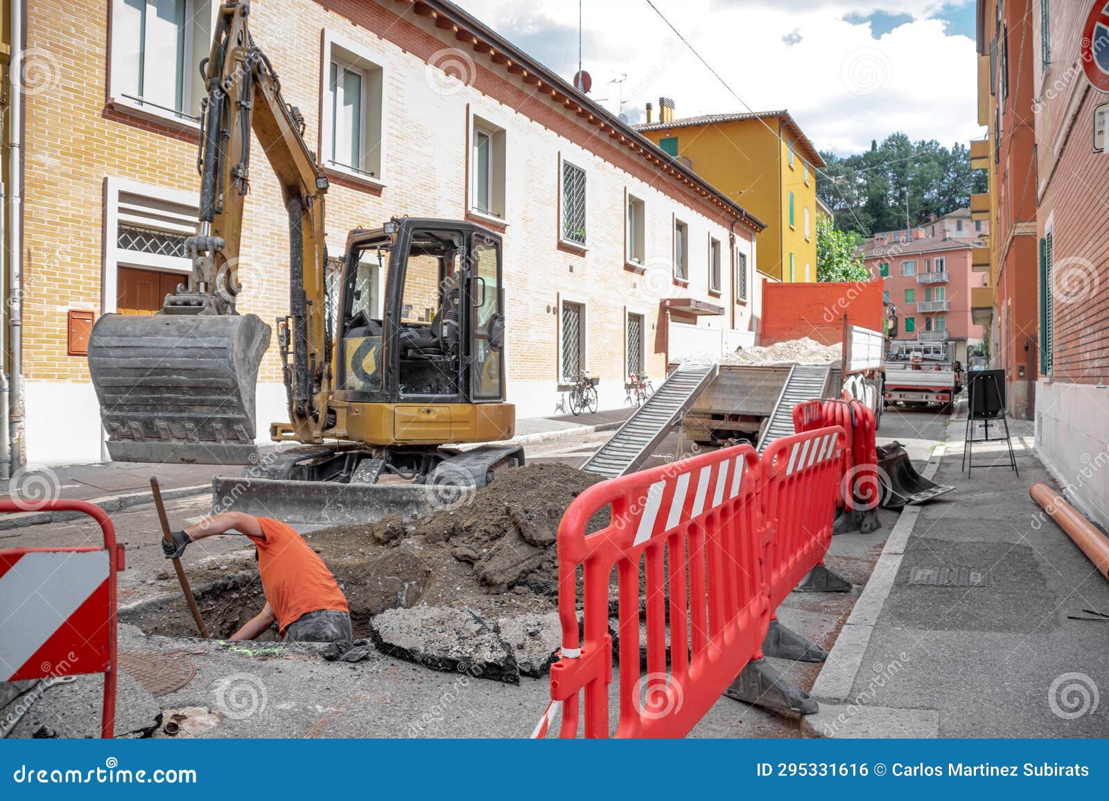 Construction Area with Operator Digging with Red Safety Barriers and ...