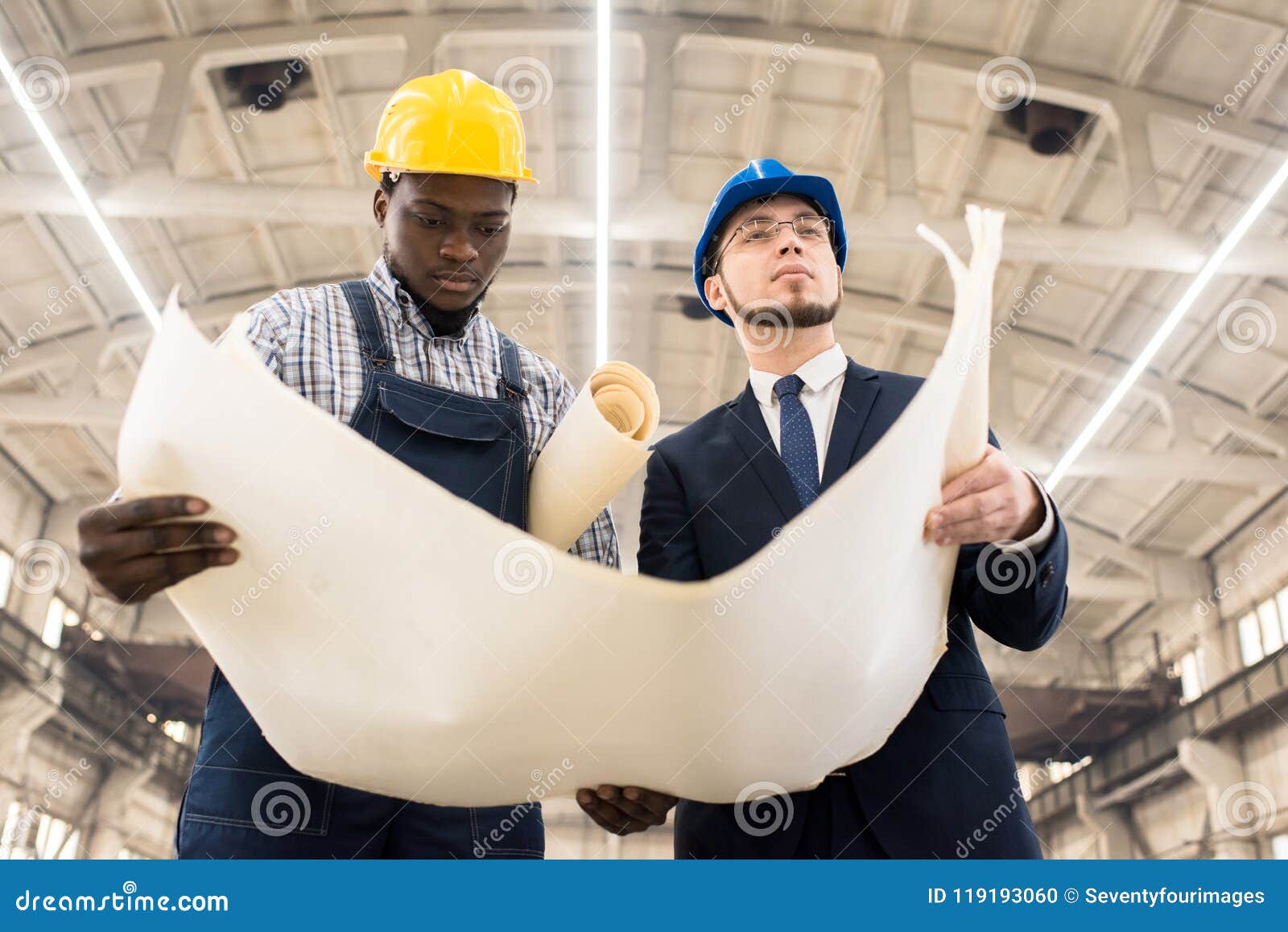 Construction Contractors Discussing Plan of Building Stock Photo ...