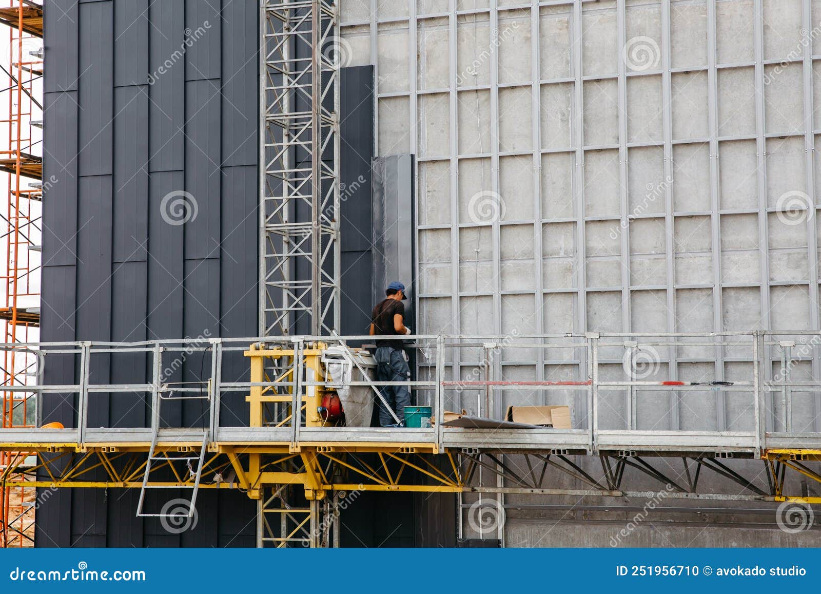 Construction Cradle with a Builder on the Wall of an Apartment Building ...