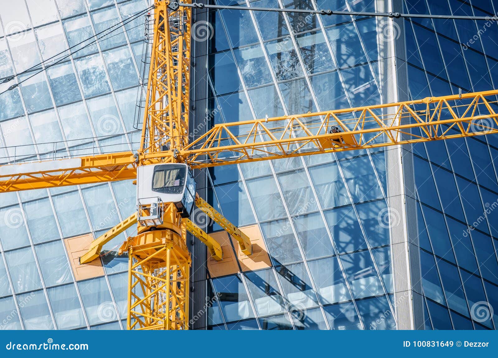 Construction Crane Against a Glass Skyscraper Under Construction. Stock ...