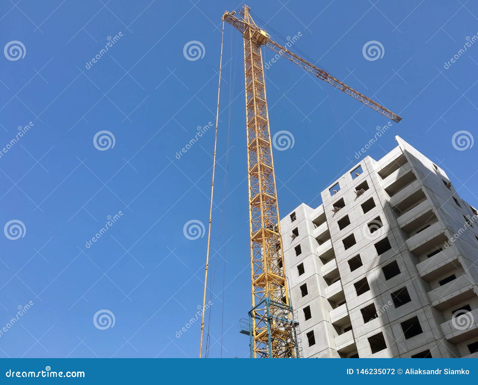 Construction Crane Rises Above the Building. Bottom Up View on Blue Sky ...