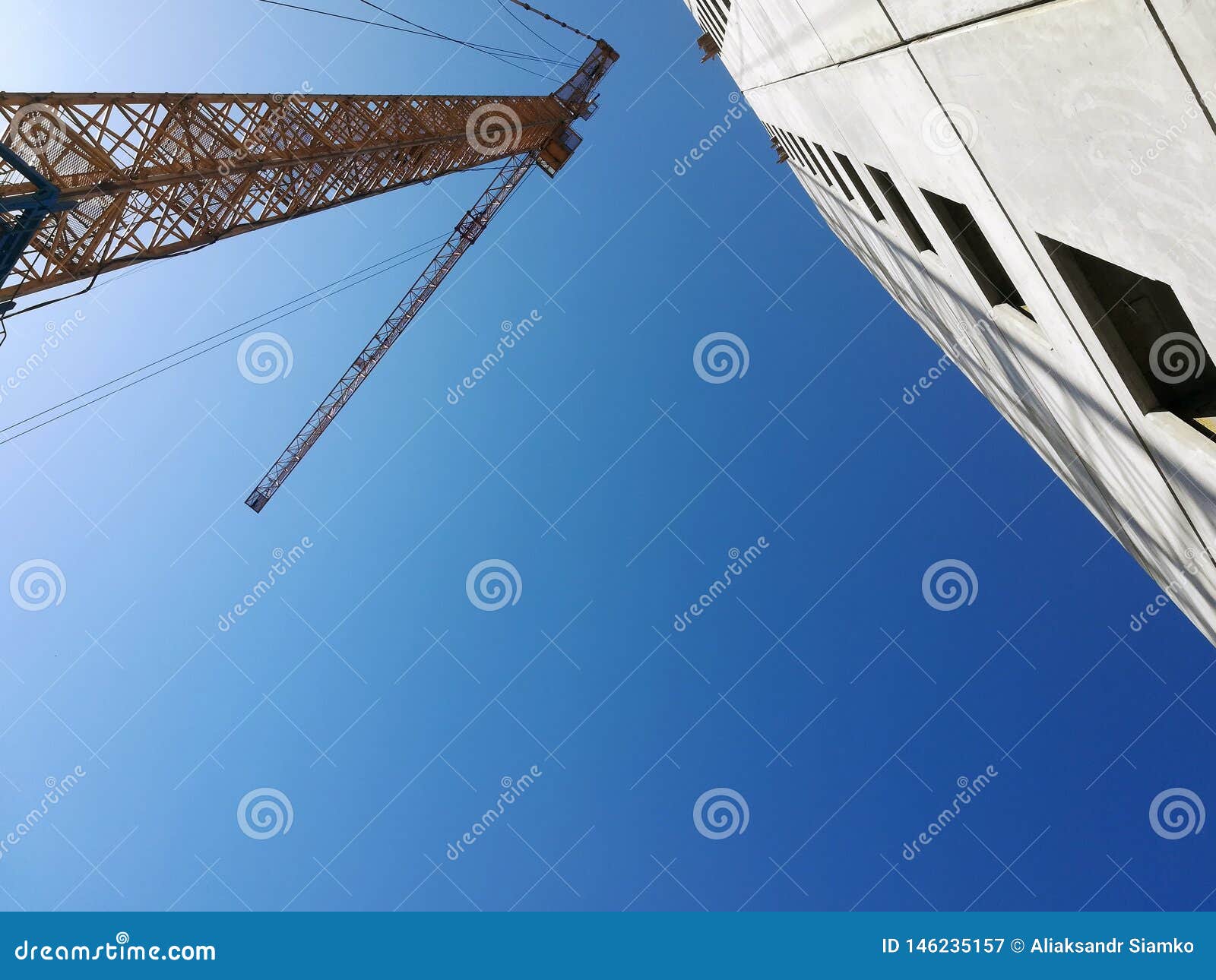 Construction Crane Rises Above the Building. Bottom Up View on Blue Sky ...