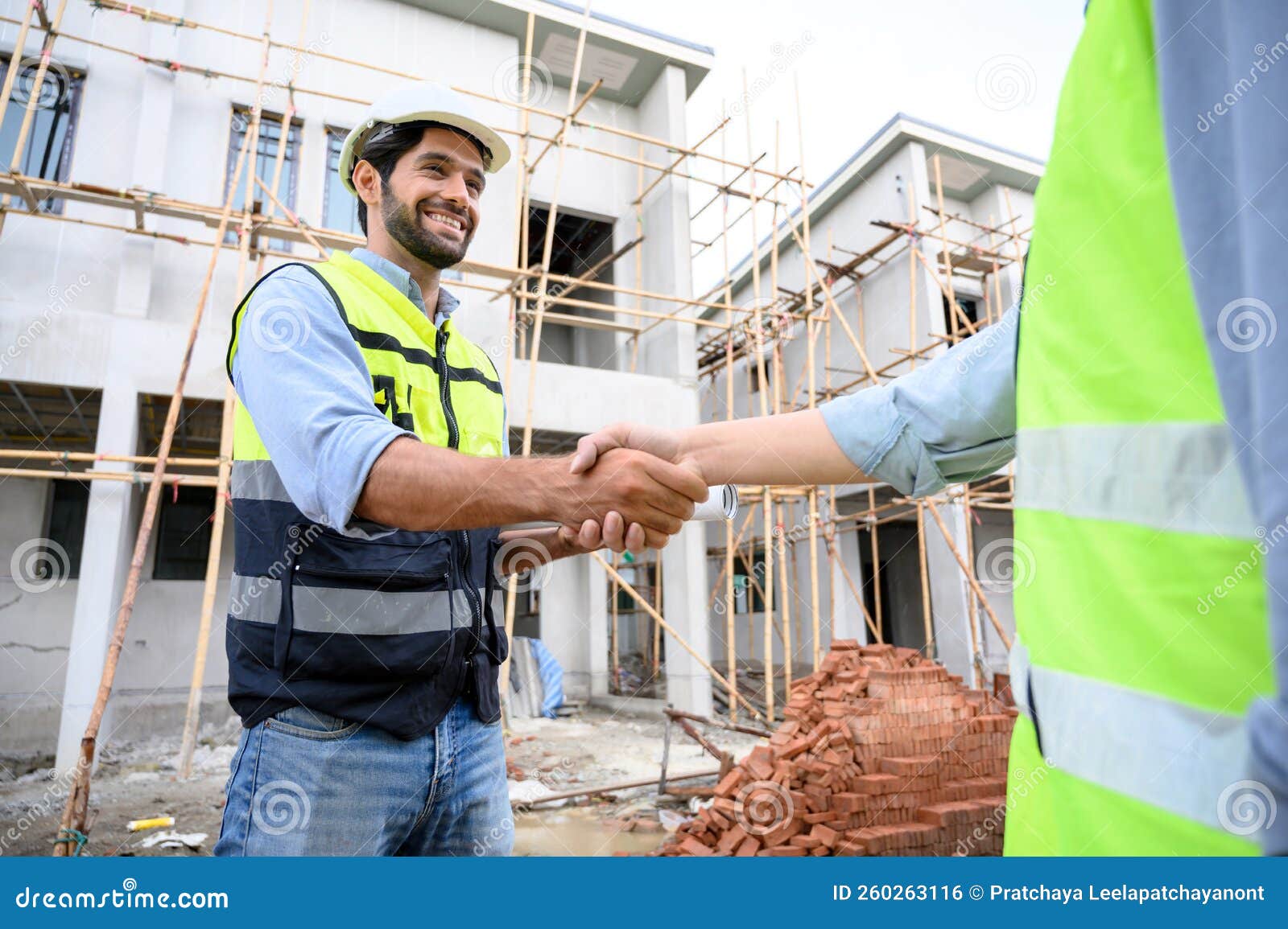 Construction Engineer and Architect with Blueprint Shaking Hands while ...