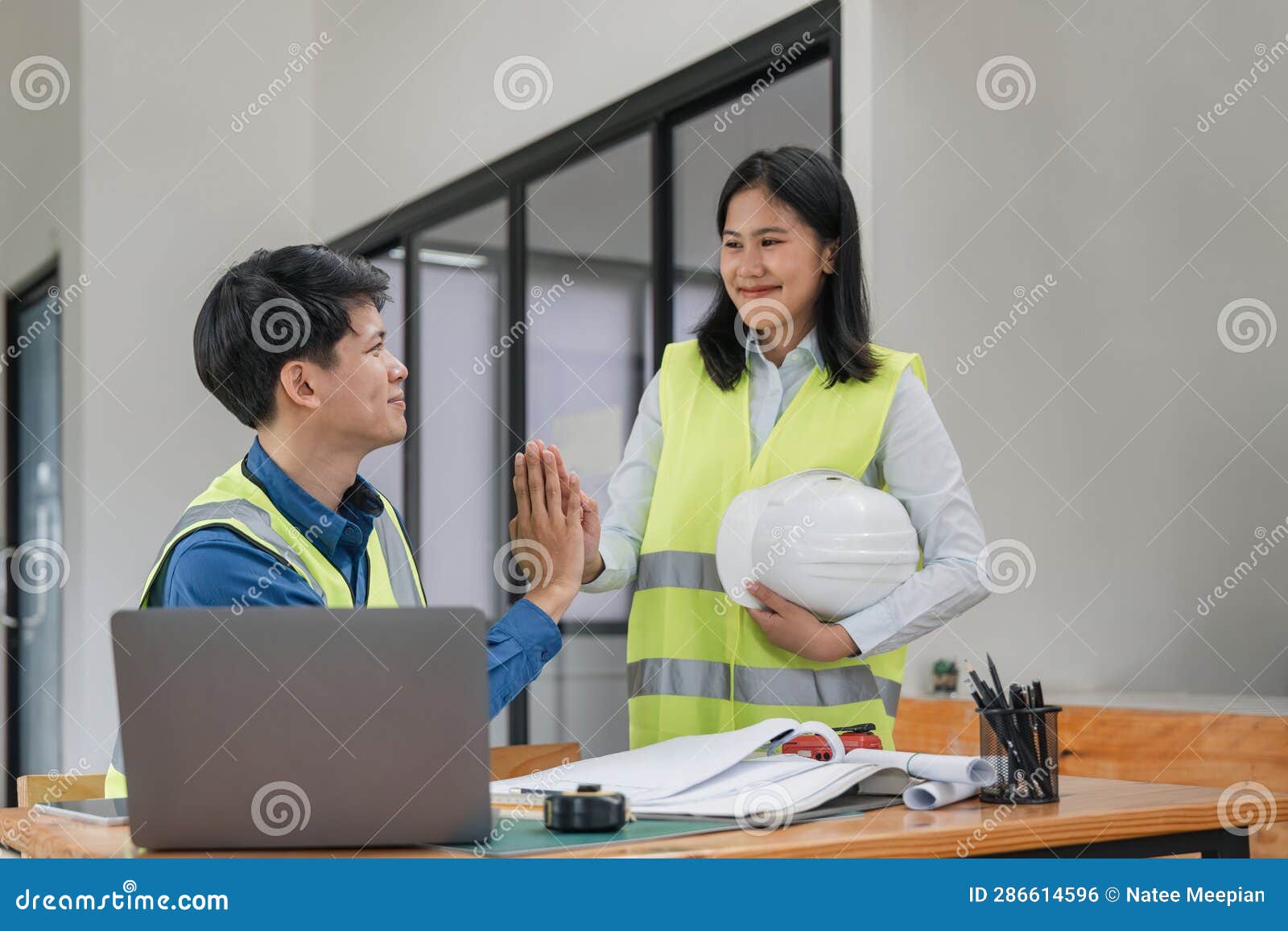 Construction Engineer with Blueprint Making High Five while Standing on ...