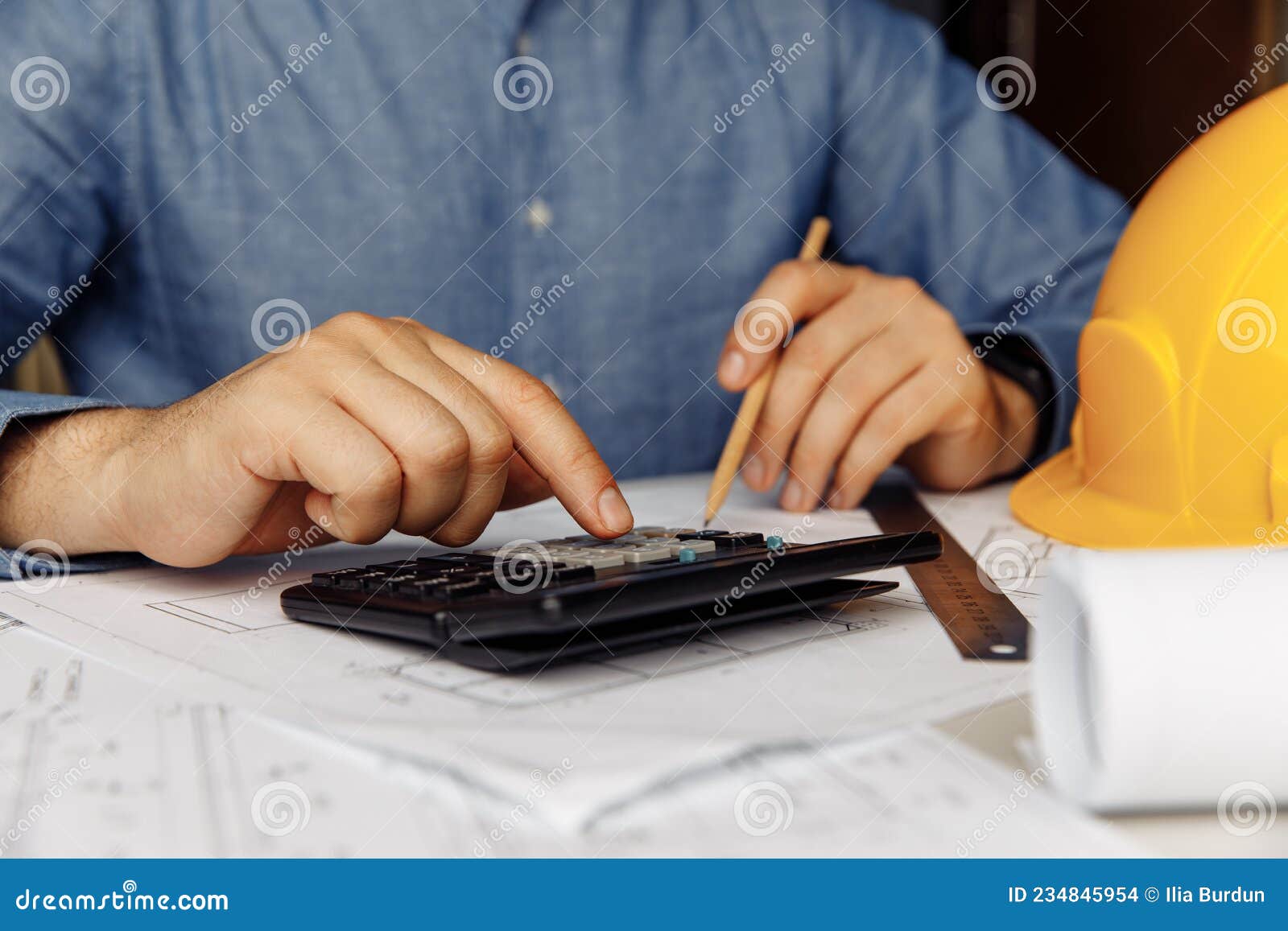 Construction Engineer Using Calculator for Analysis in the Office ...