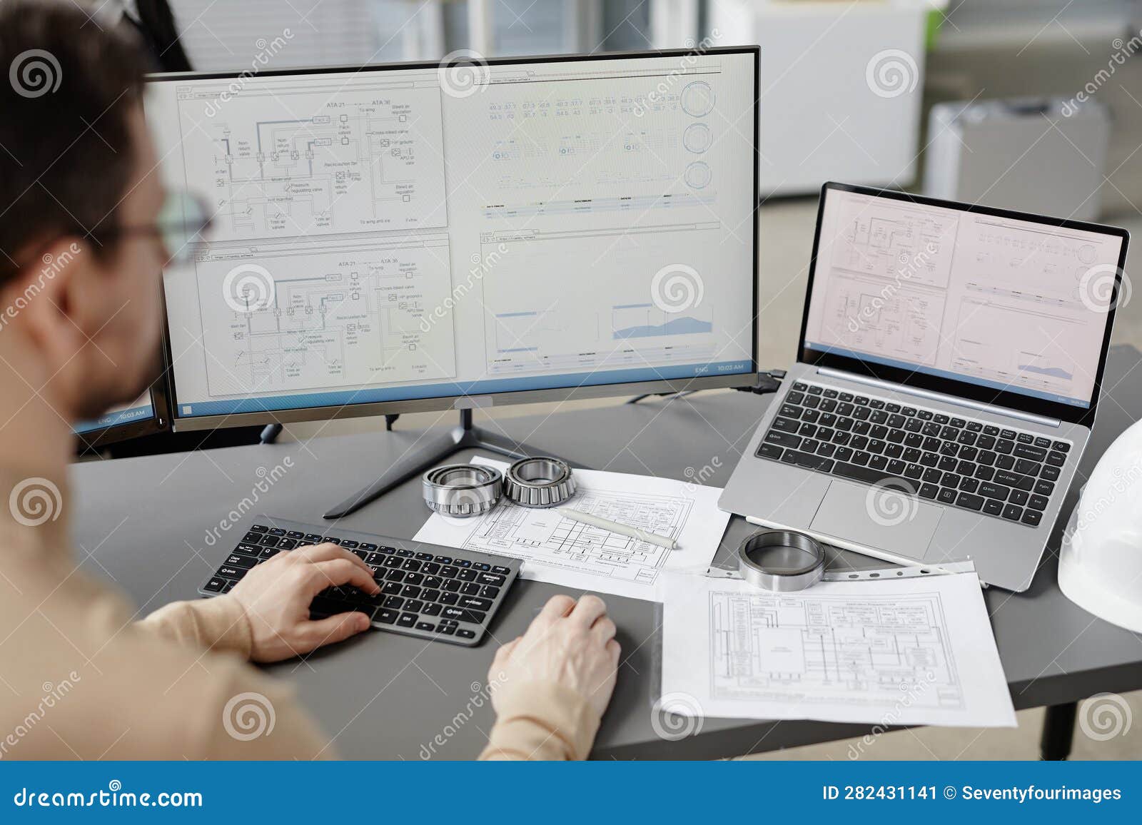 Construction Engineer at Workplace Using Computer with Blueprints on ...
