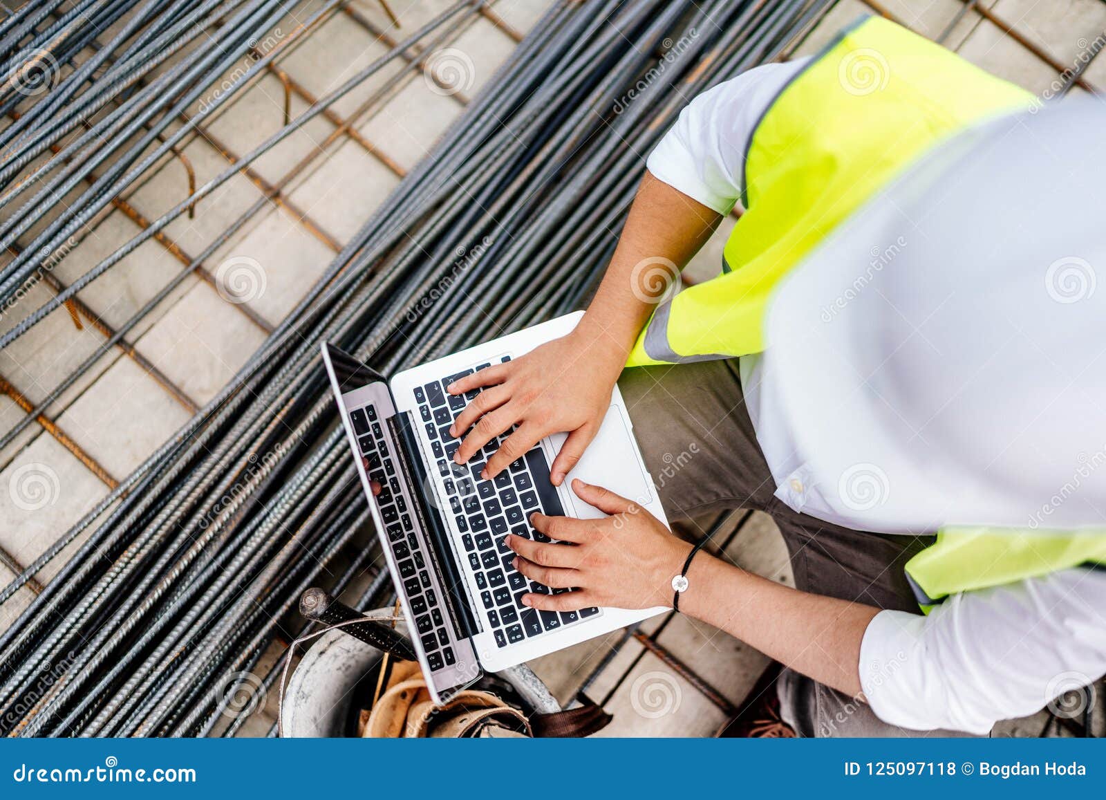 Construction Engineer Writing Report on Laptop at Construction Site ...