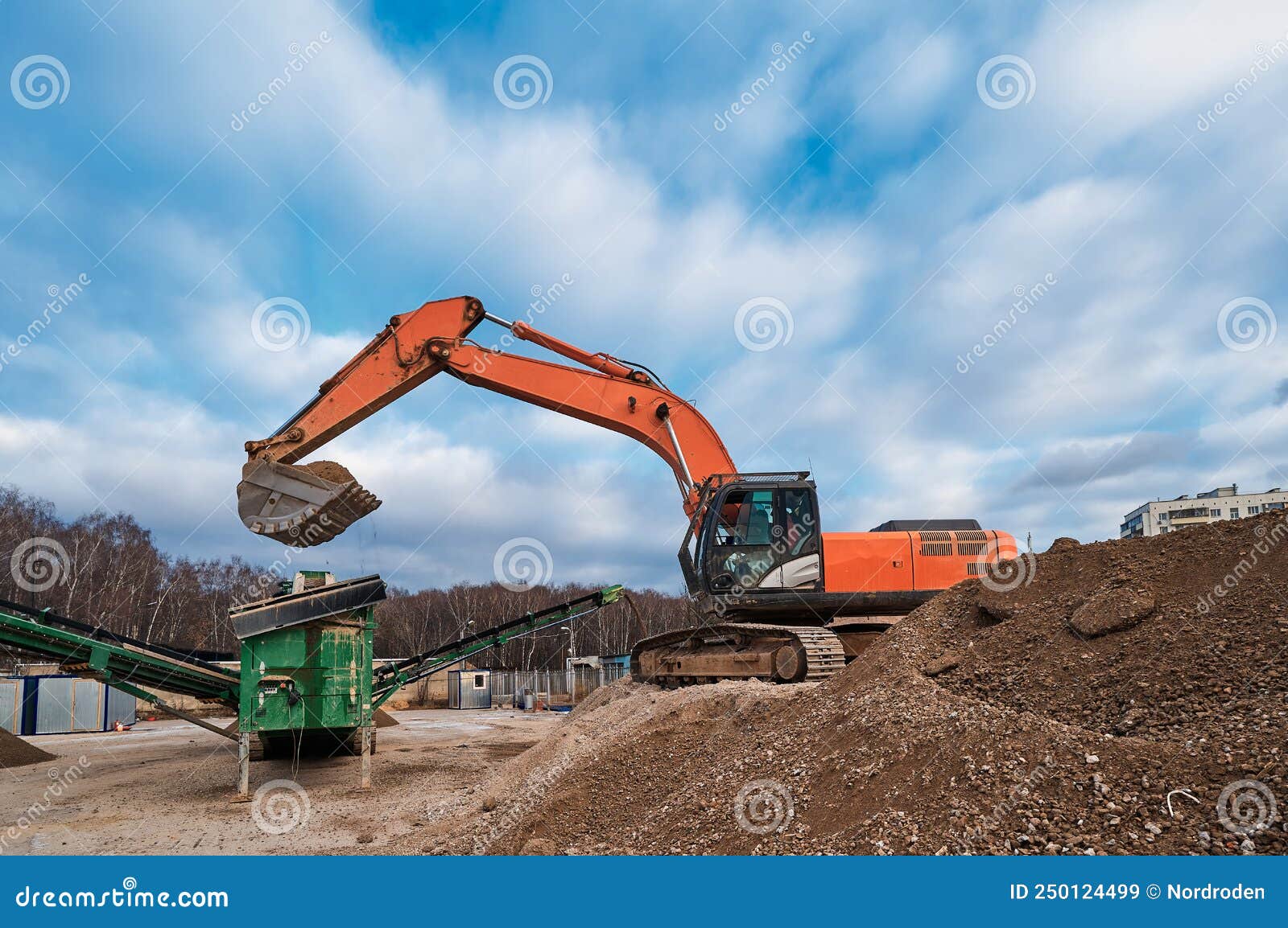 A Construction Excavator Loads Crushed Stone into the Receiving Hopper ...