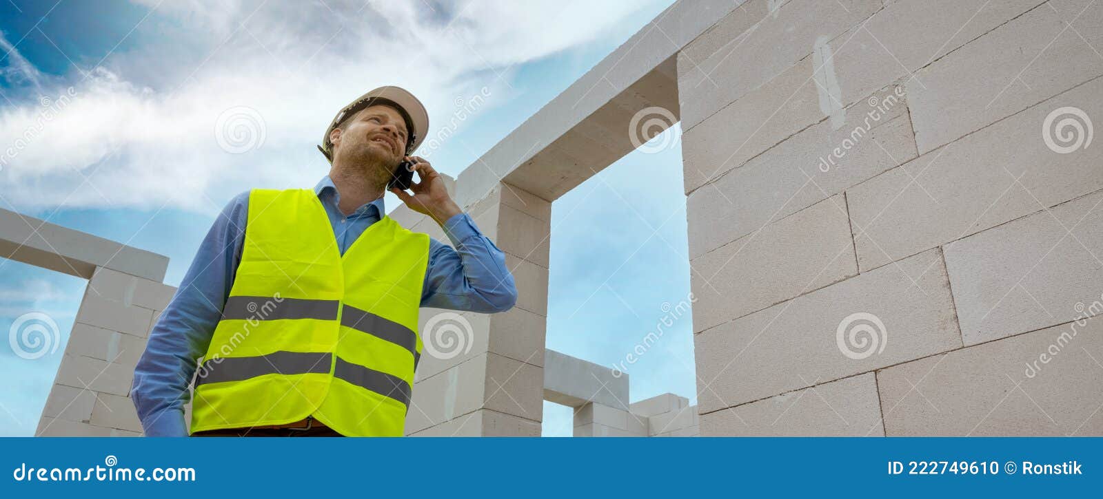 Construction Foreman Talking on the Mobile Phone at Building Site. Copy ...