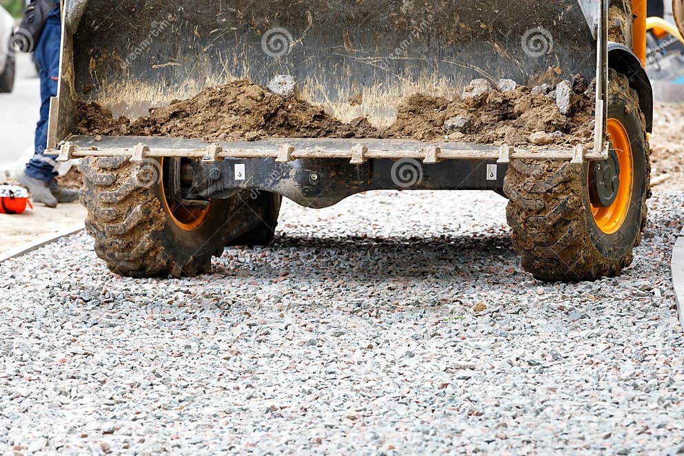 A Construction Grader Bucket Against the Backdrop of a Sidewalk Under ...