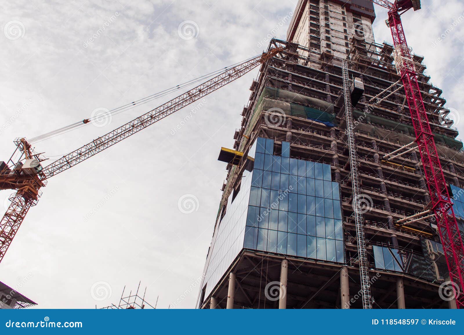 Building Cranes At Front Of A Multi-storey Uilding Under Construction ...
