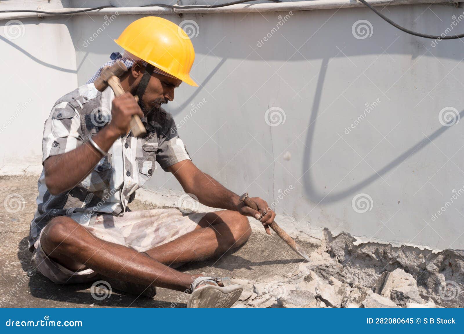 A Construction Labour Working with Hammer and Chisel Wearing Safety ...