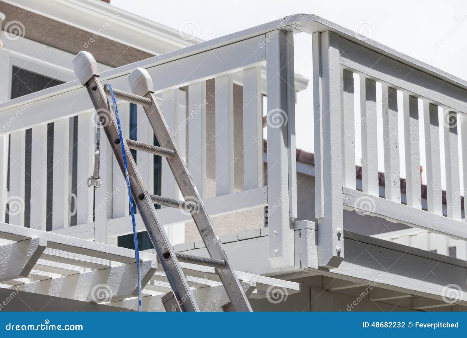 Construction Ladder and Painting Hose Leaning on House Deck Stock Photo ...