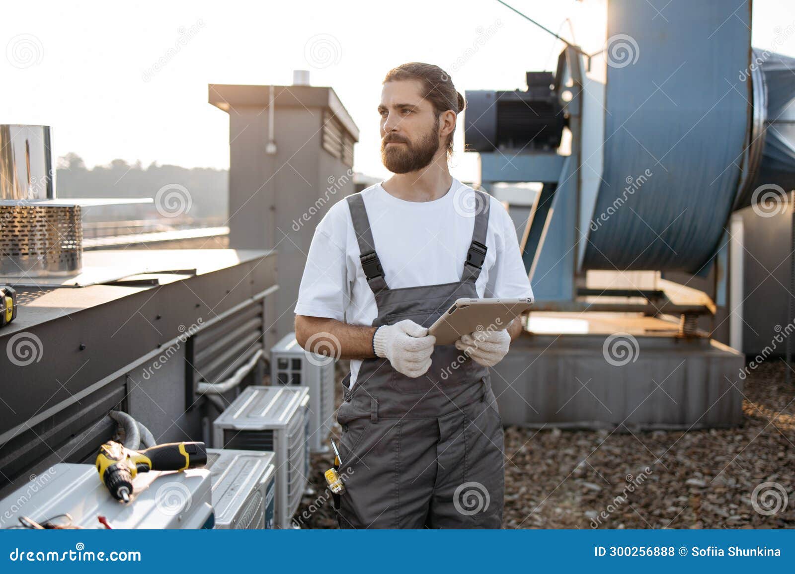 Construction Man Using Tablet while Working on Rooftop Stock Photo ...