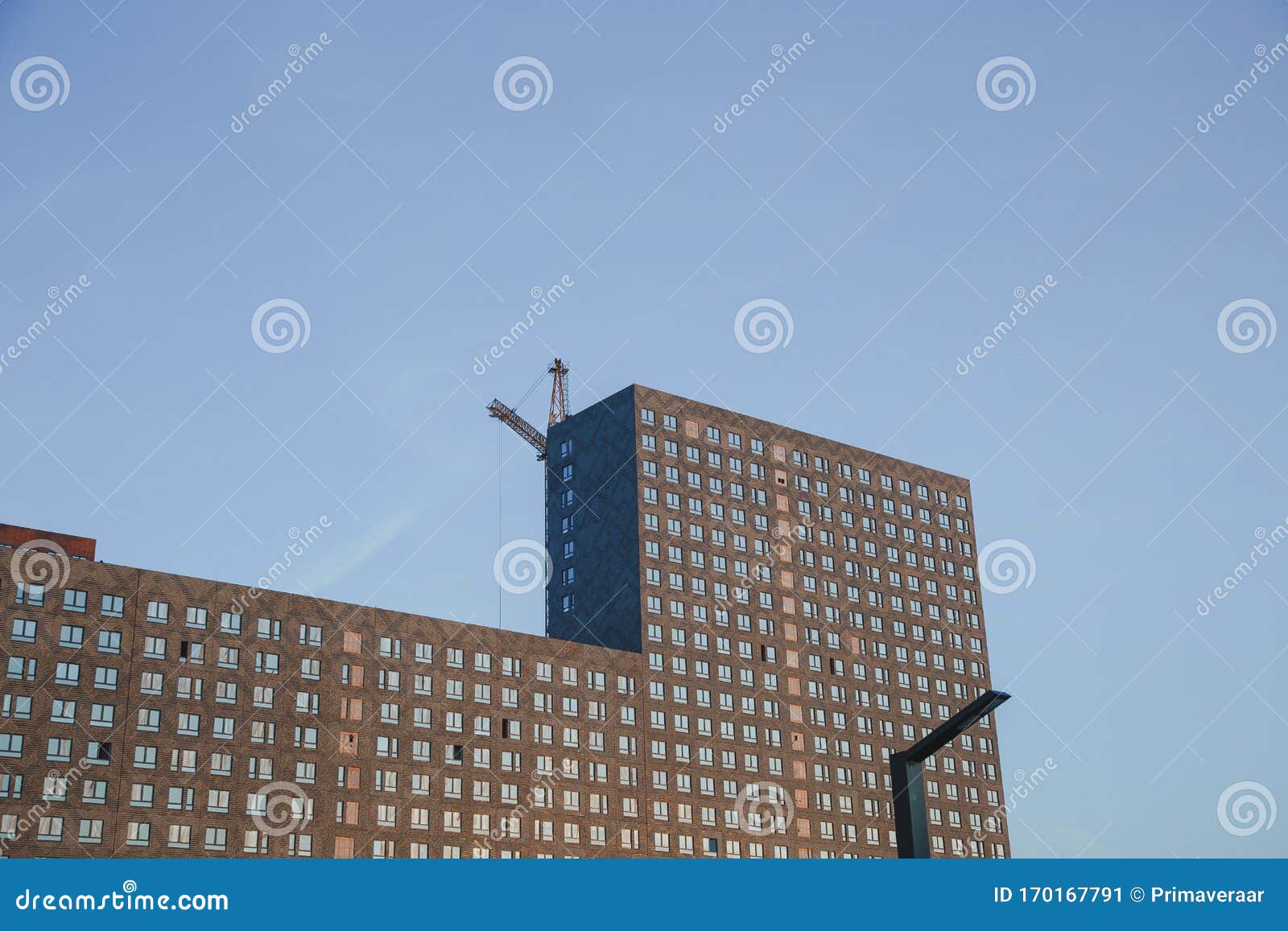 Construction of a Modern Apartment Building: Crane Against Blue Sky ...