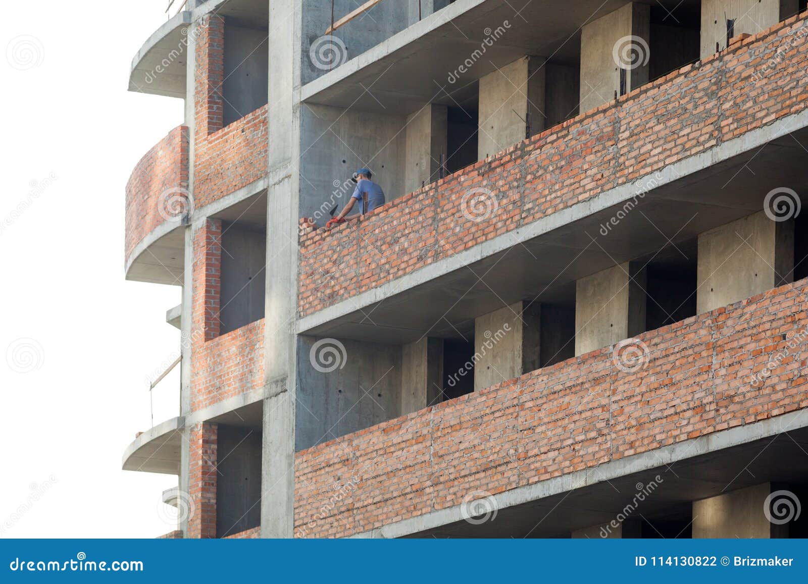 Construction Of A New Multi-storey Building. A Man Worker Puts A Brick ...