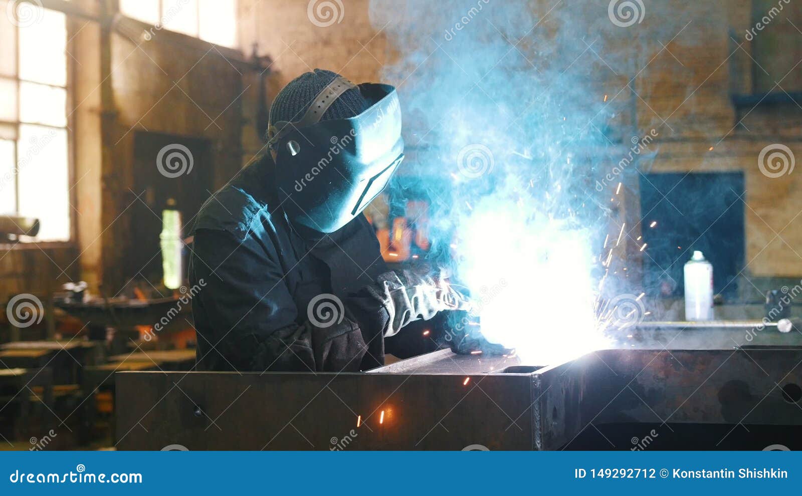 Construction Plant. a Man Worker in a Helmet Using a Welding Machine ...