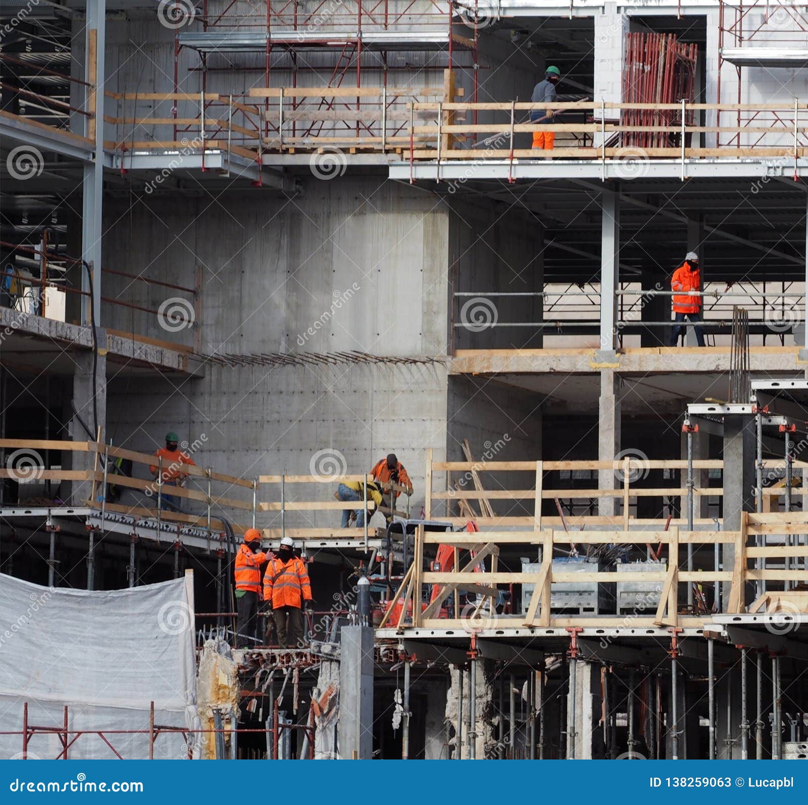 Construction Site Activity. Workers with Work Wears in a New Building ...