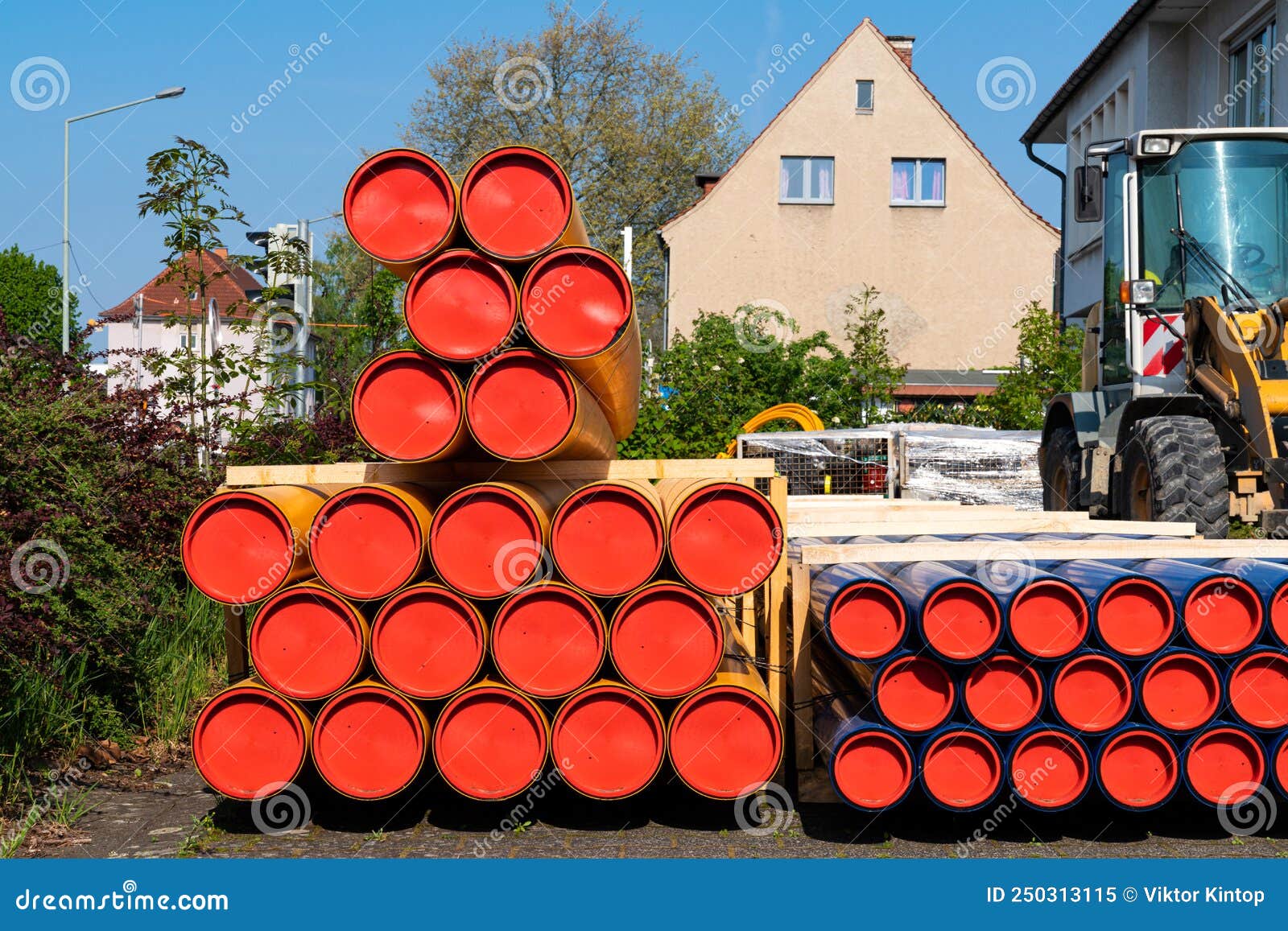 Construction Site. Tractor and Stack of Orange-yellow and Blue PVC ...