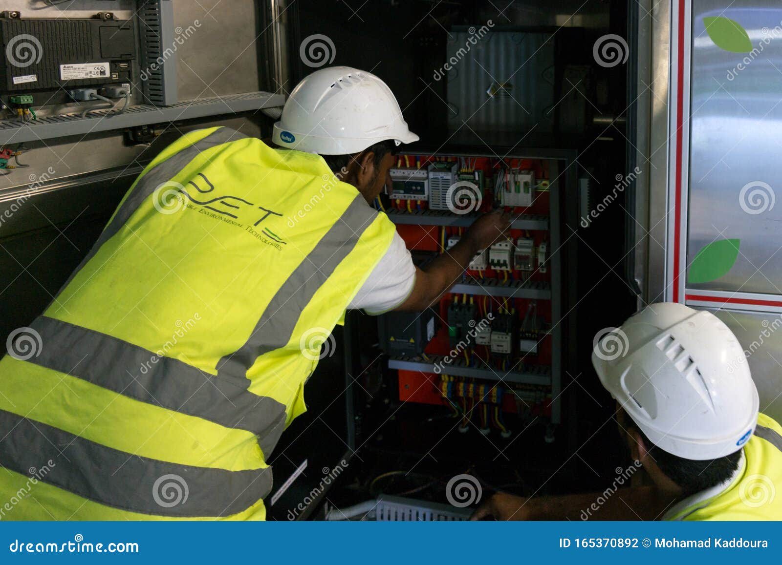 Construction Site with Engineers and Workers Fixing a Machine in a ...
