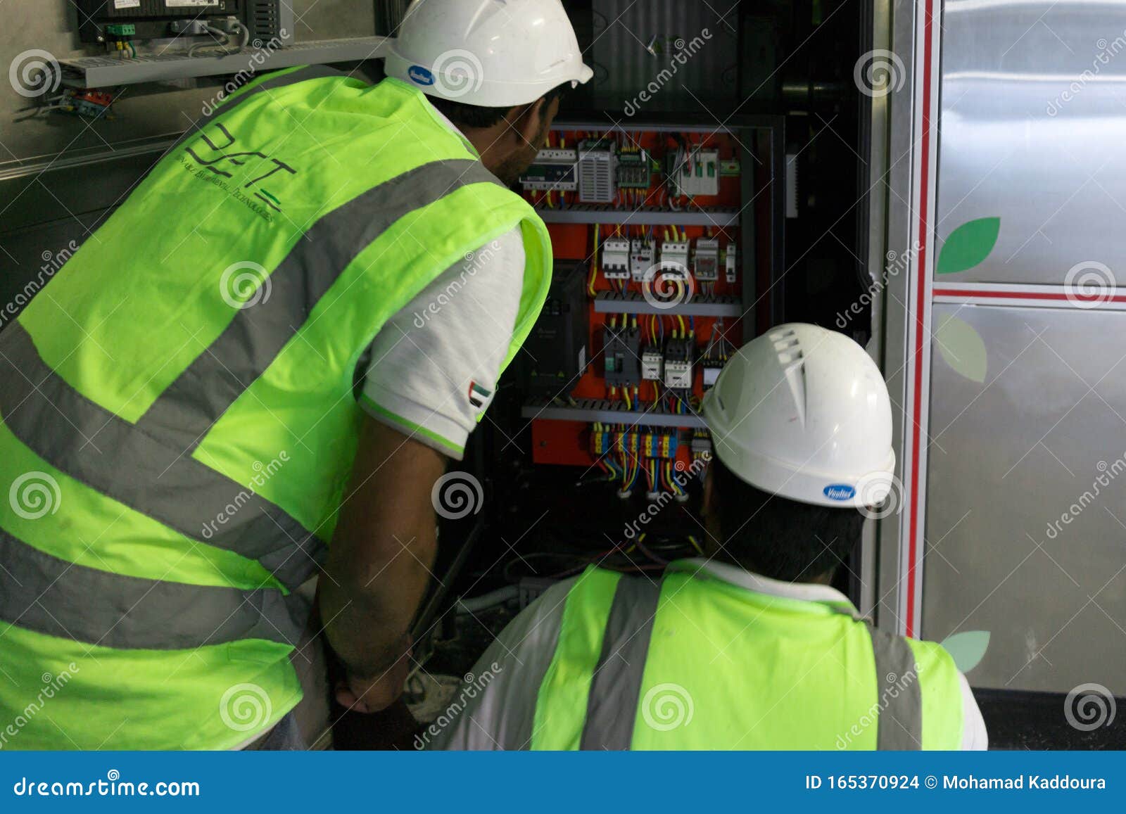 Construction Site with Engineers and Workers Fixing a Machine in a ...