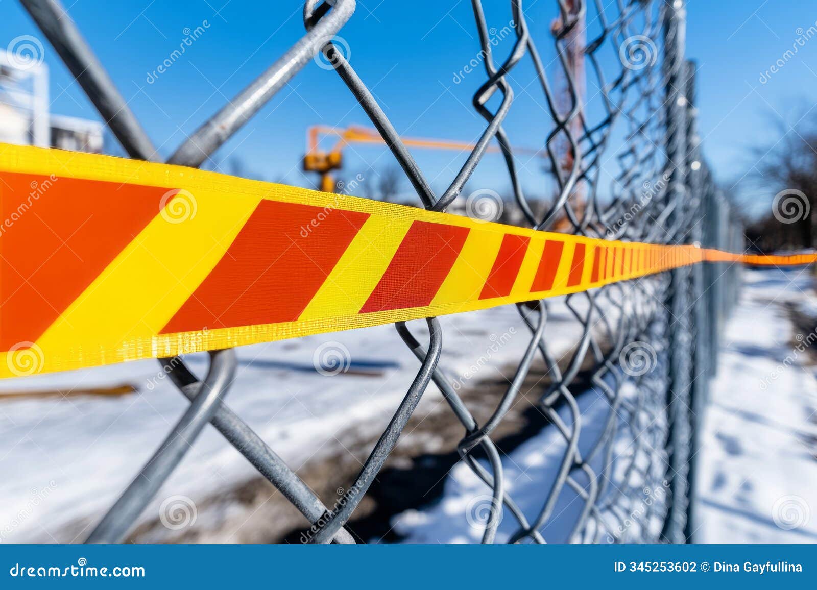 A Construction Site Fence with Bright Caution Tape Stretched between ...