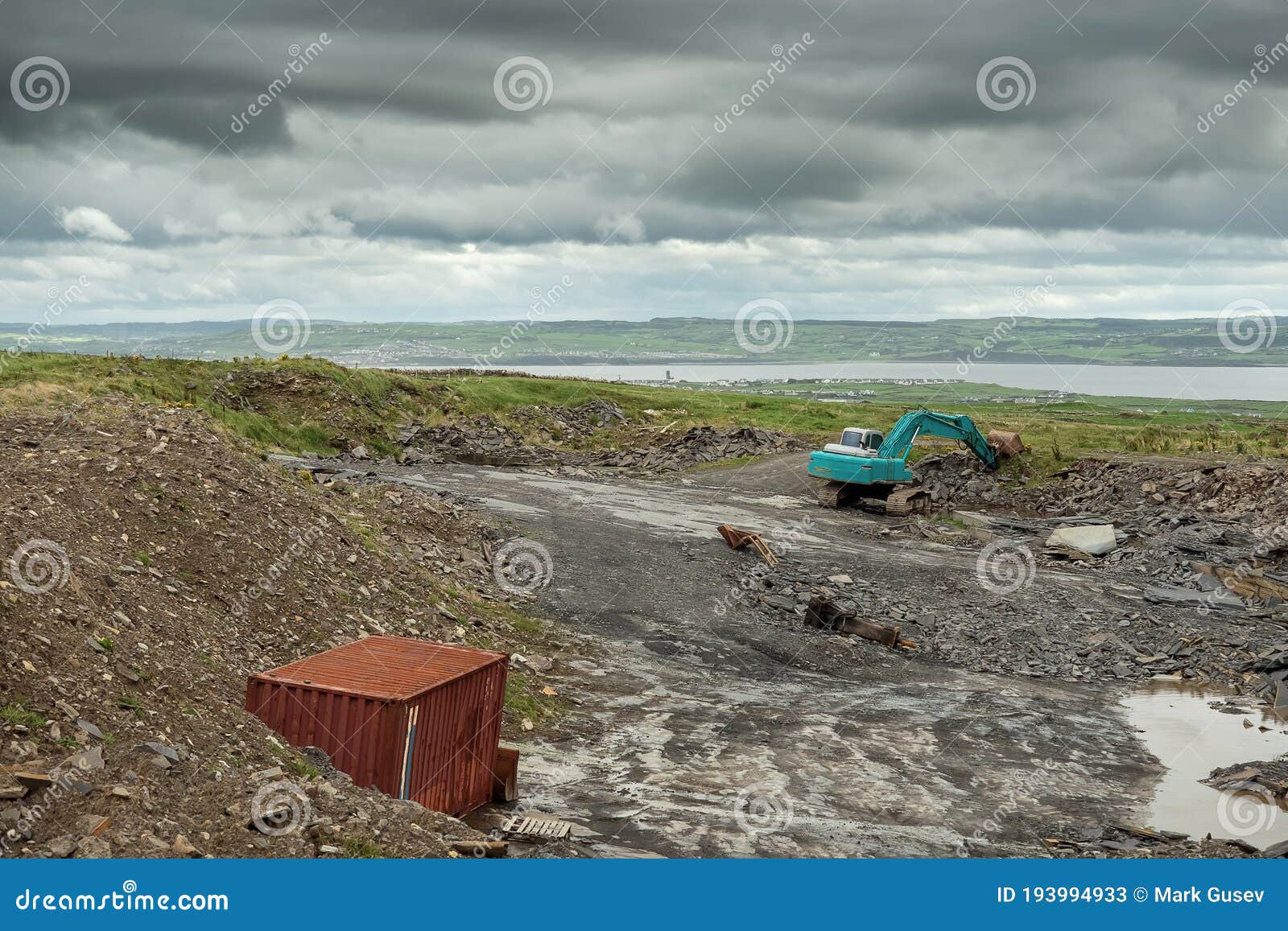 Construction Site in a Field with Blue Color Excavator Working. Dark ...