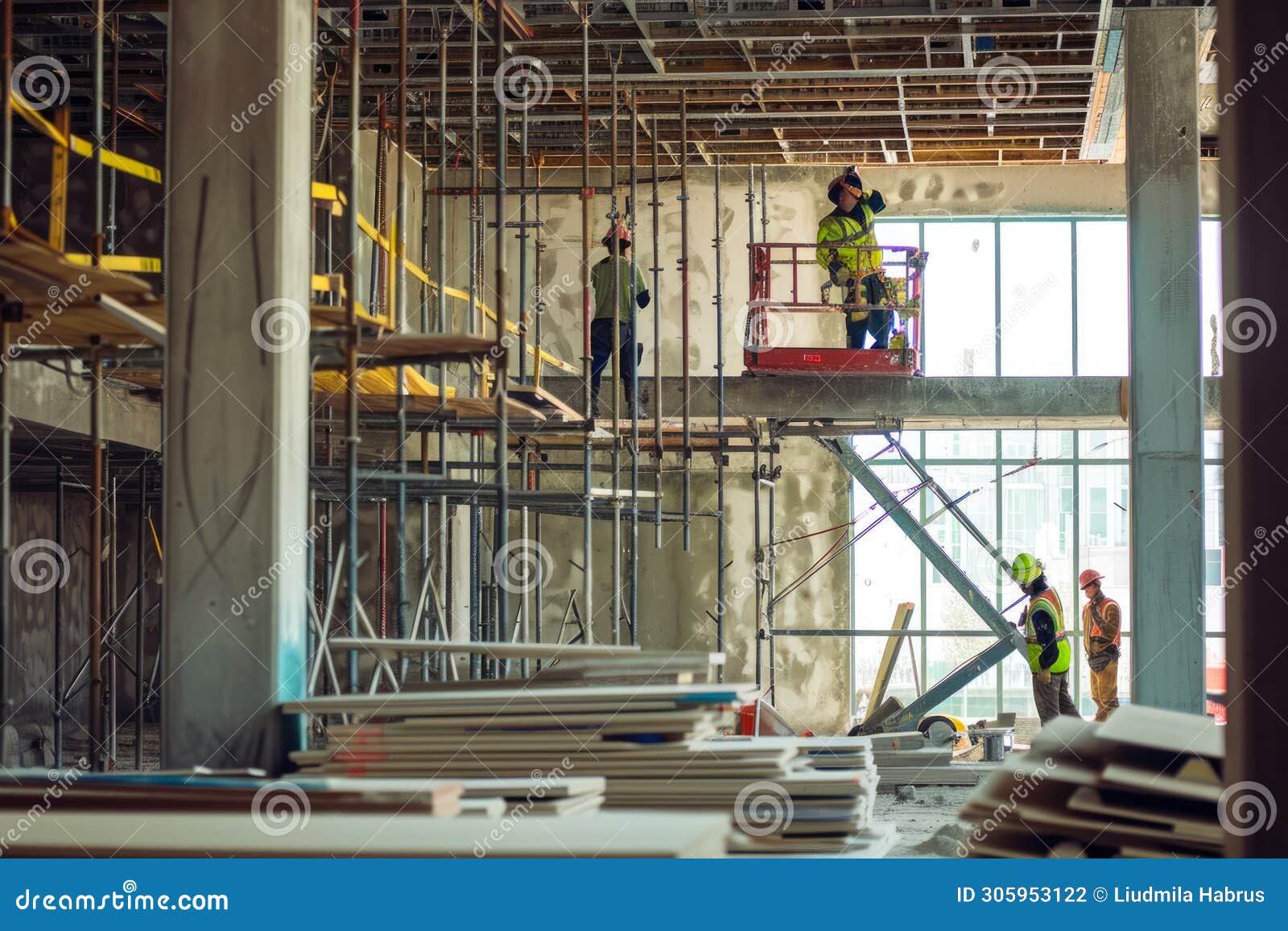 Construction Site with a Group of Workers Installing Drywall in a New ...