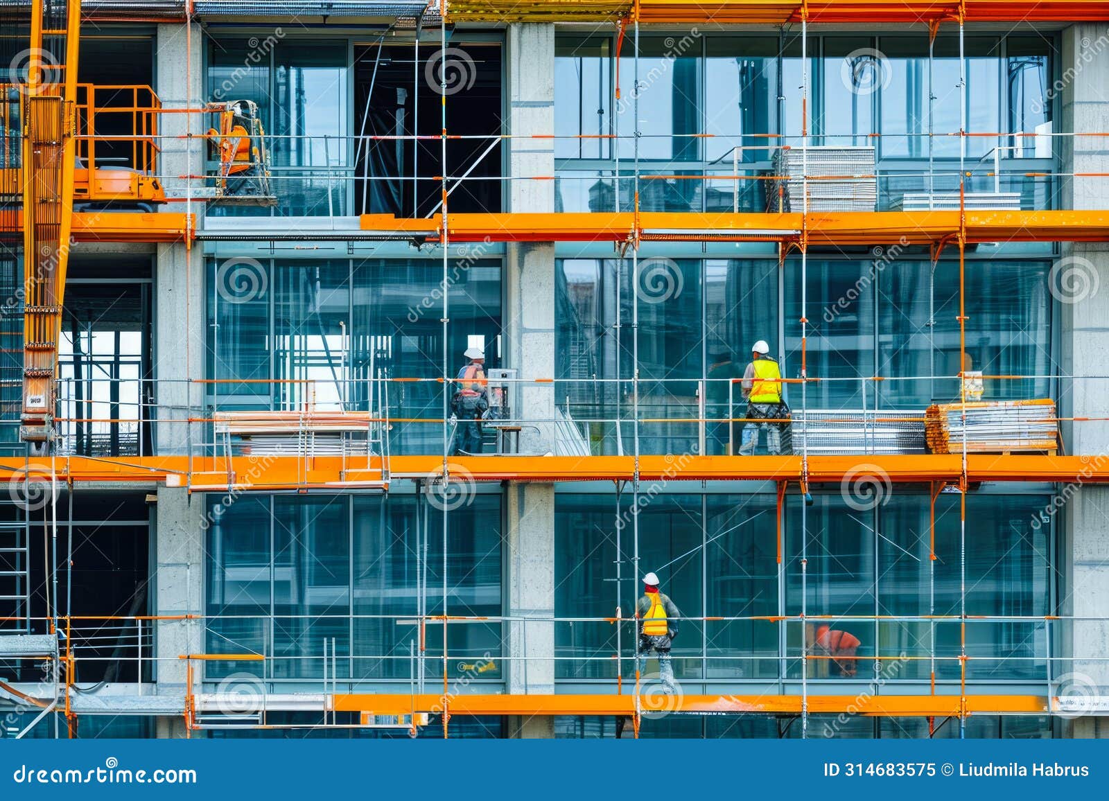Construction Site with a Group of Workers Installing Windows in a New ...