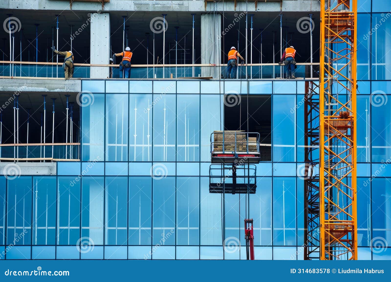 Construction Site with a Group of Workers Installing Windows in a New ...
