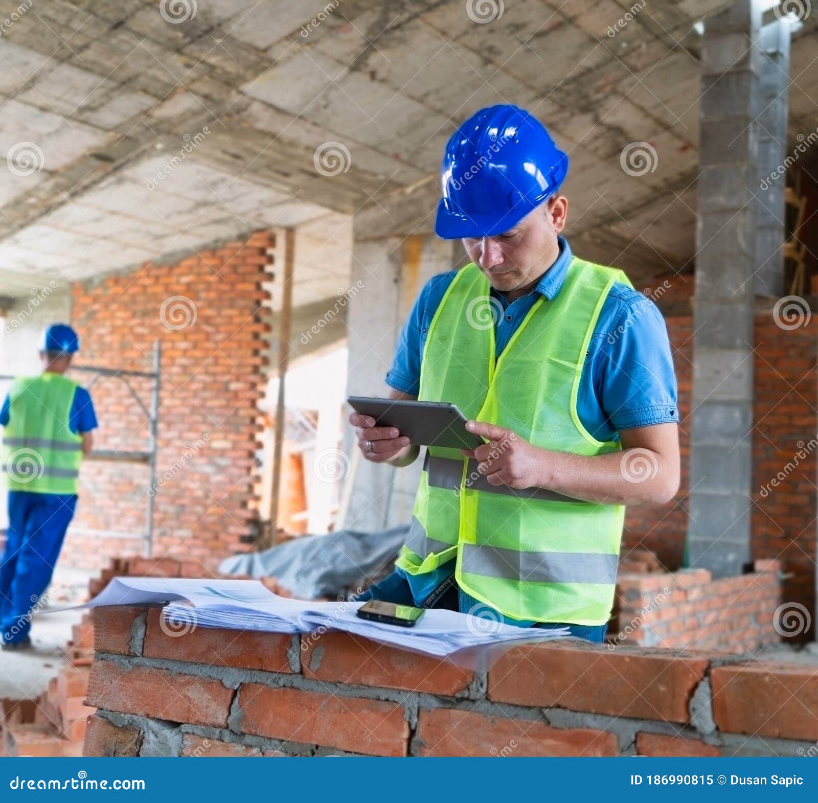 Construction Site Manager Looks at the Tablet Picture.Construction Site ...