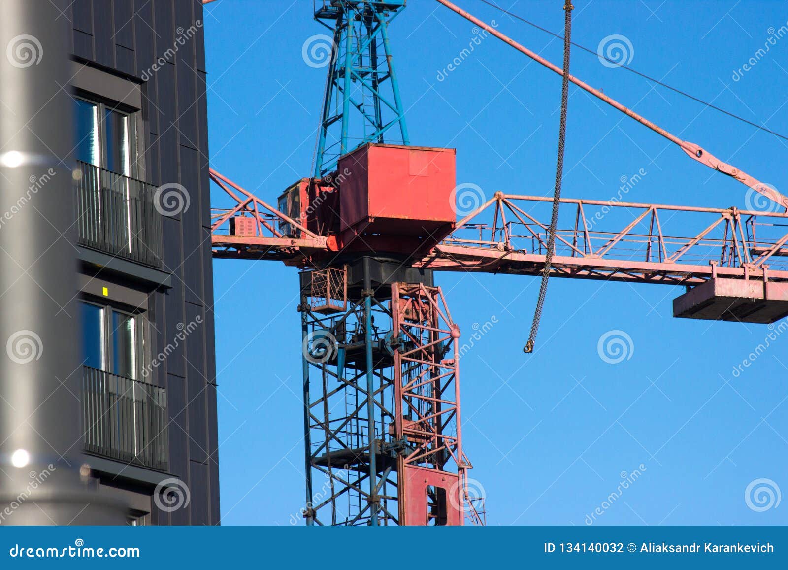 Construction Site with Red Crane on Blue Sky Background and Grey House ...