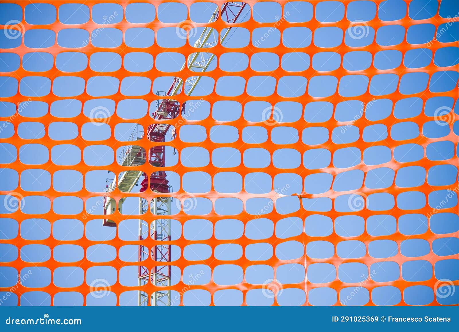 Construction Site with Safety Plastic Orange Grid Against a Tower Crane ...