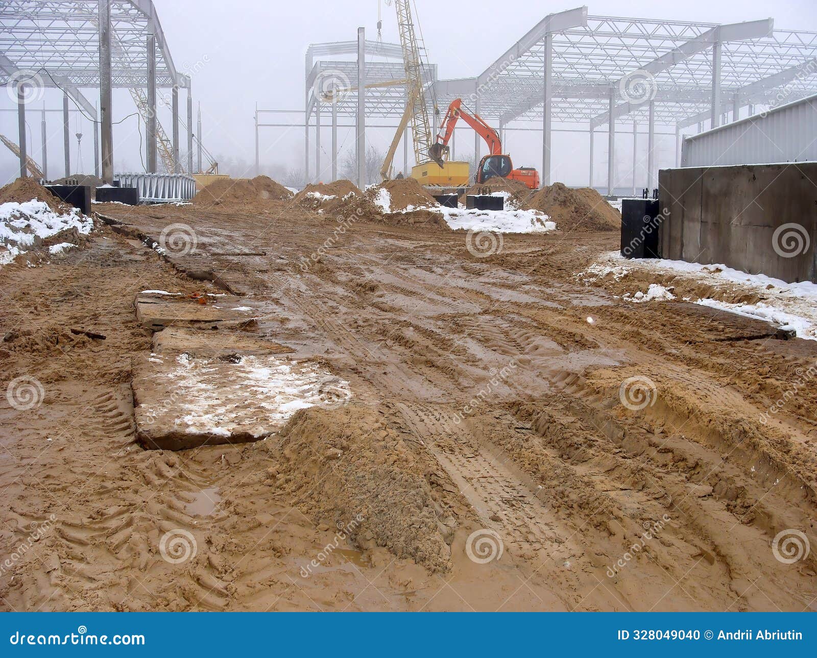 Construction Site with Steel Framework and Muddy Ground, Machinery in ...