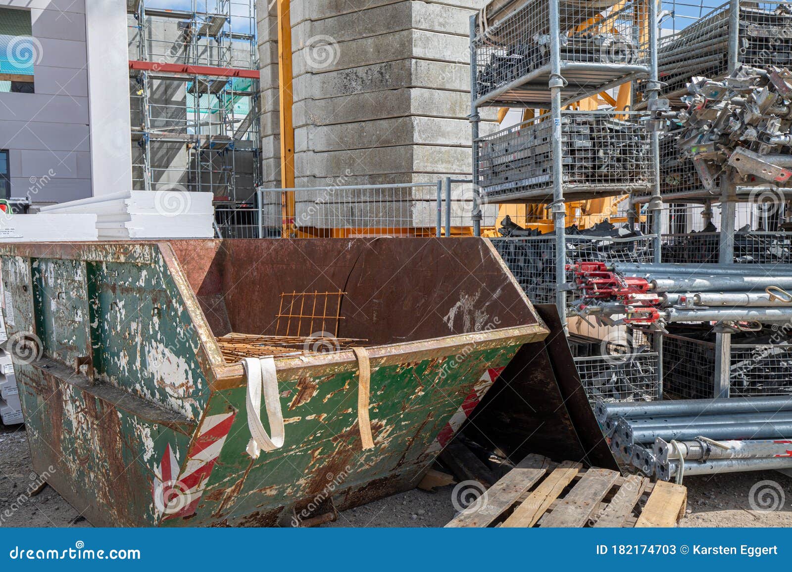 On Construction Site, a Waste Container Stands Next To a Shelf with ...