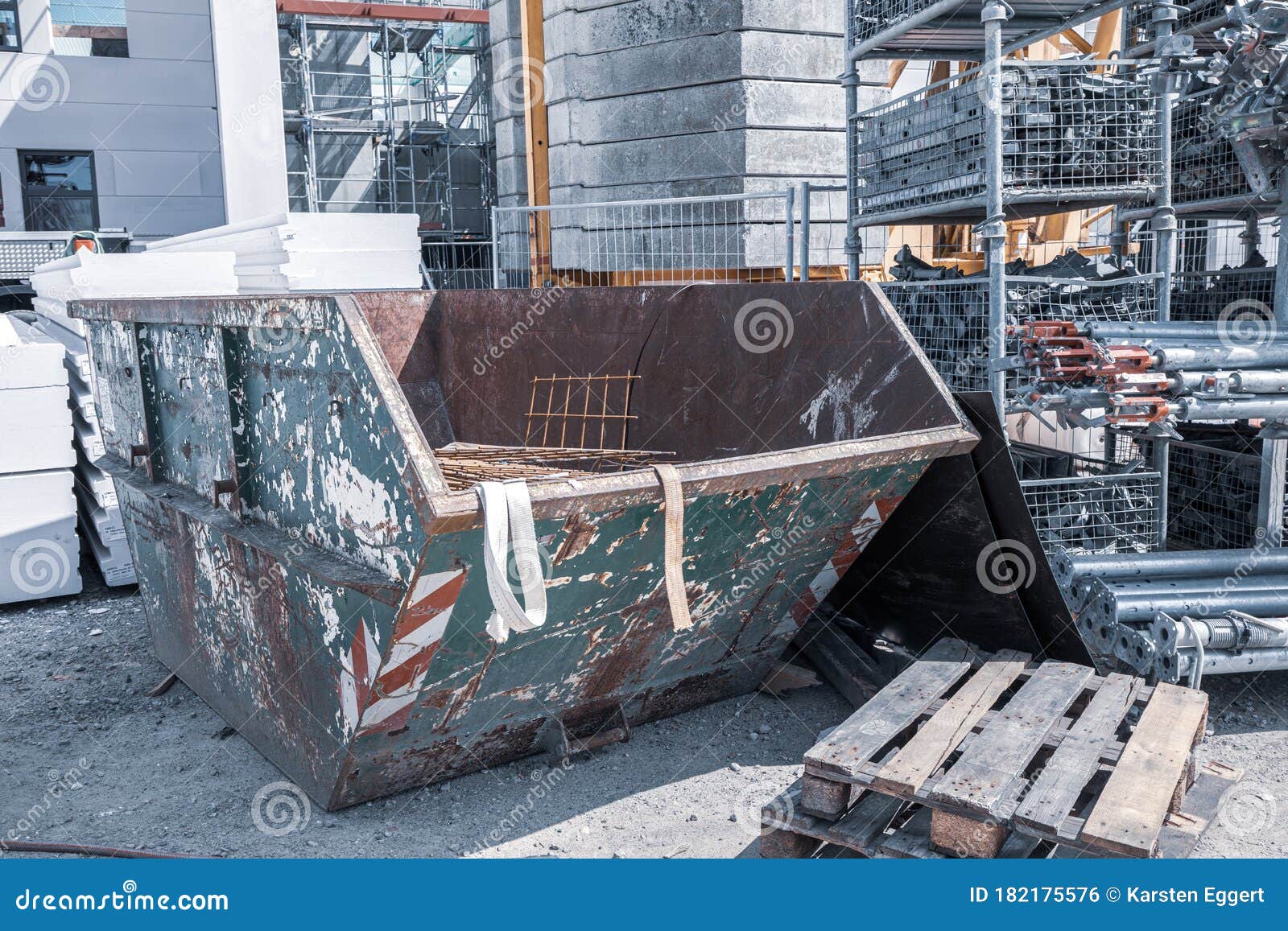 On Construction Site, a Waste Container Stands Next To a Shelf with ...